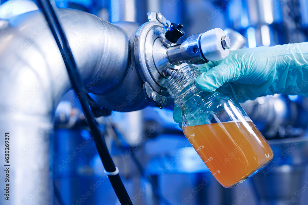 Laboratory assistant inspecting production beer, analysis drink in ...