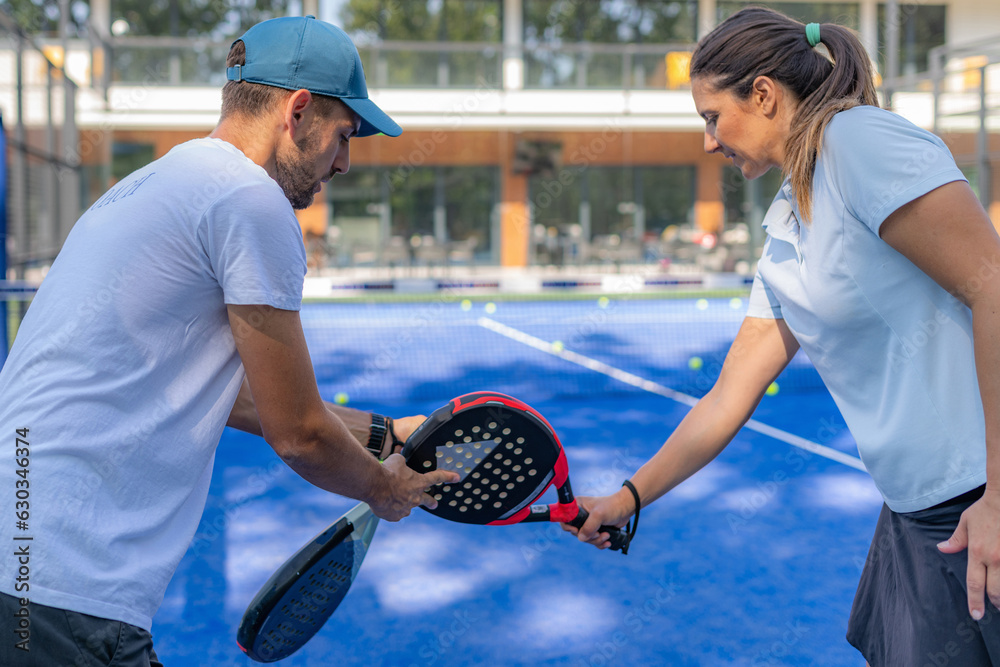 Padel training, a skilled coach teaches a woman the art of playing ...