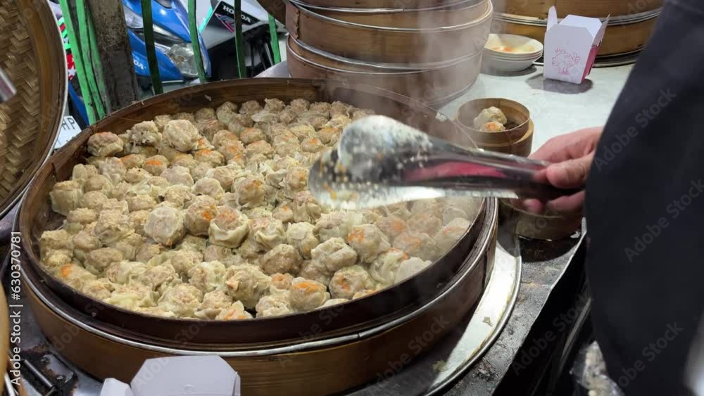 Street food booth selling traditional dumpling named Dim Sum with piles ...