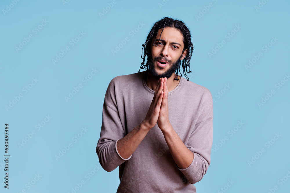 Arab man pleading with folded hands and hopeful facial expression ...
