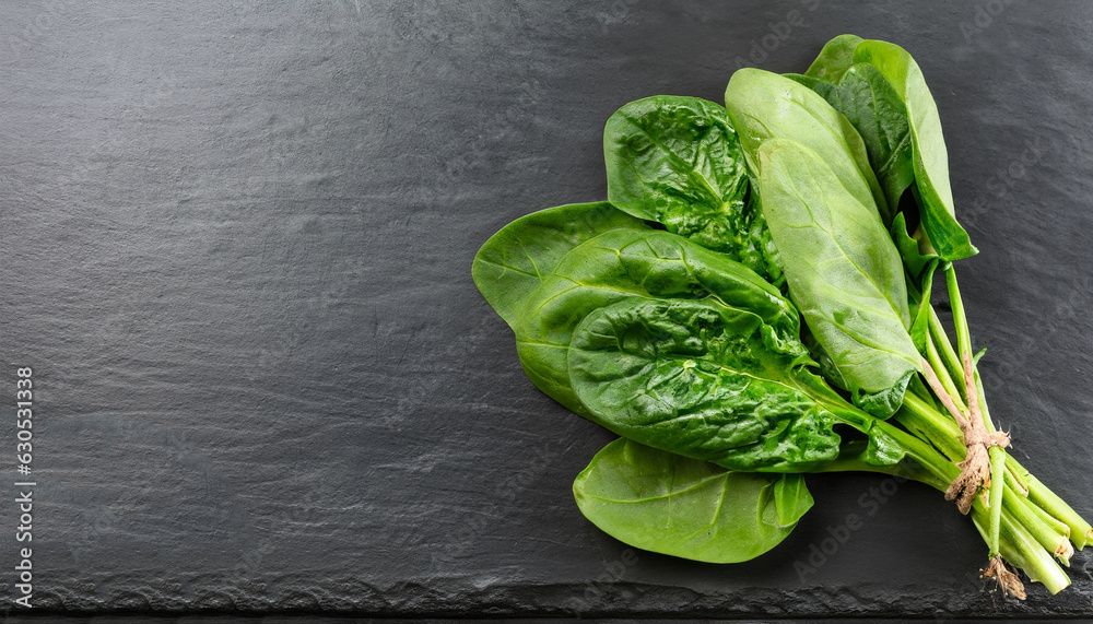 Freshly picked spinach on the black slate board, top view, Space for ...
