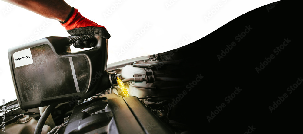 Car mechanic pouring engine oil into engine, changing engine oil, car ...