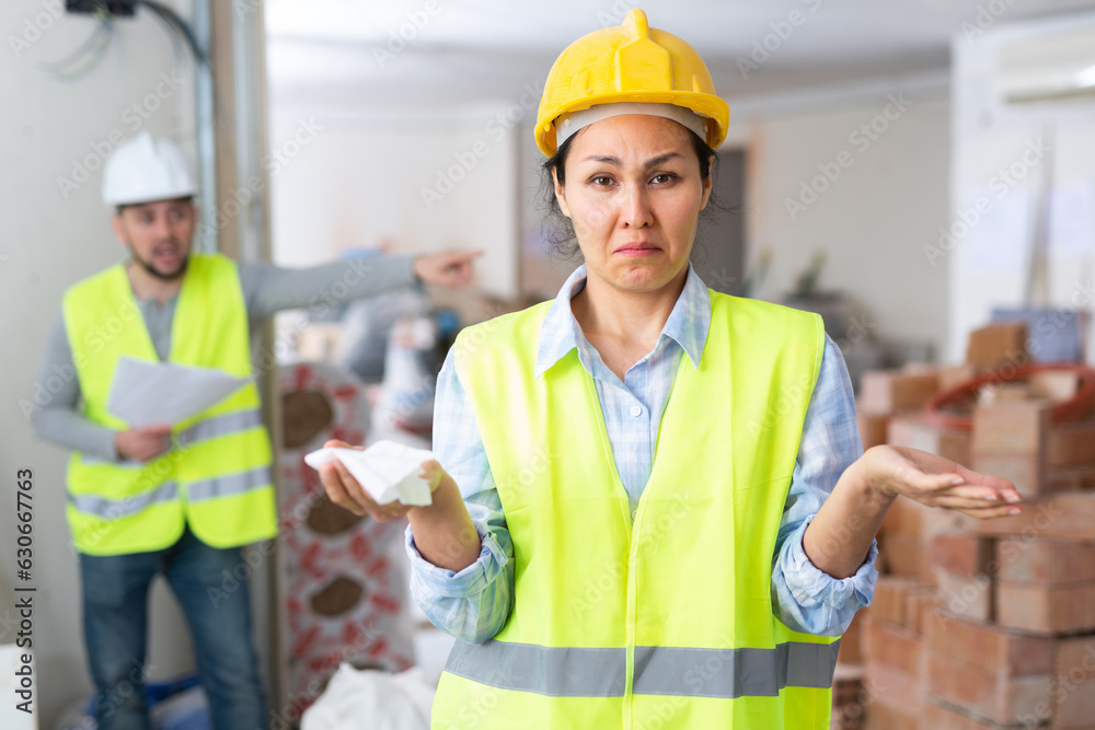 Upset puzzled asian female construction worker in yellow safety vest ...