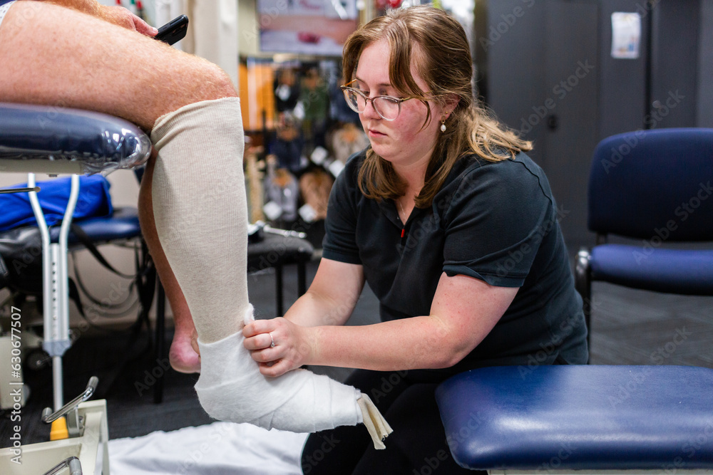 medical professional putting walking cast on leg Stock Photo | Adobe Stock