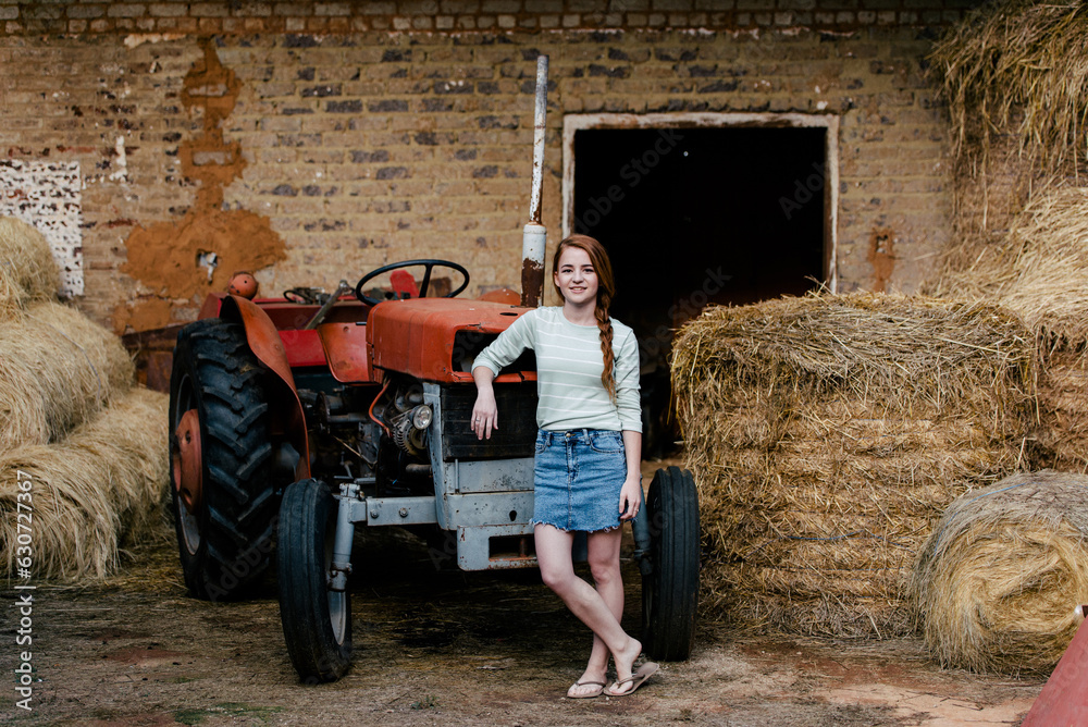 Farm girl farmer lady hay tractor farm work red hair Demin skirt shed ...