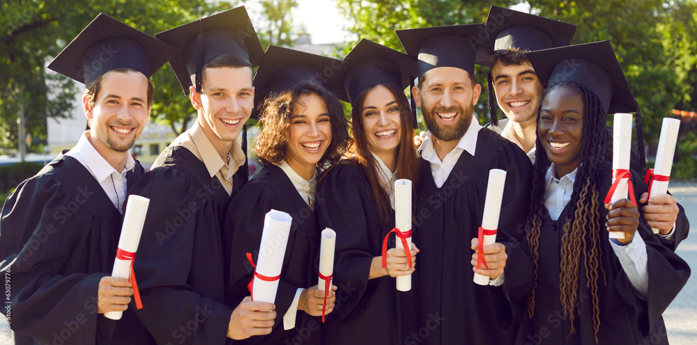 Happy diverse graduates in college campus yard. Group portrait of seven ...