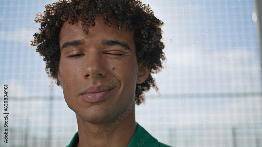 Curly model winking camera at stadium background portrait. Smiling man ...