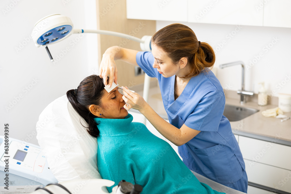 Doctor making marks on face of female patient before injection ...
