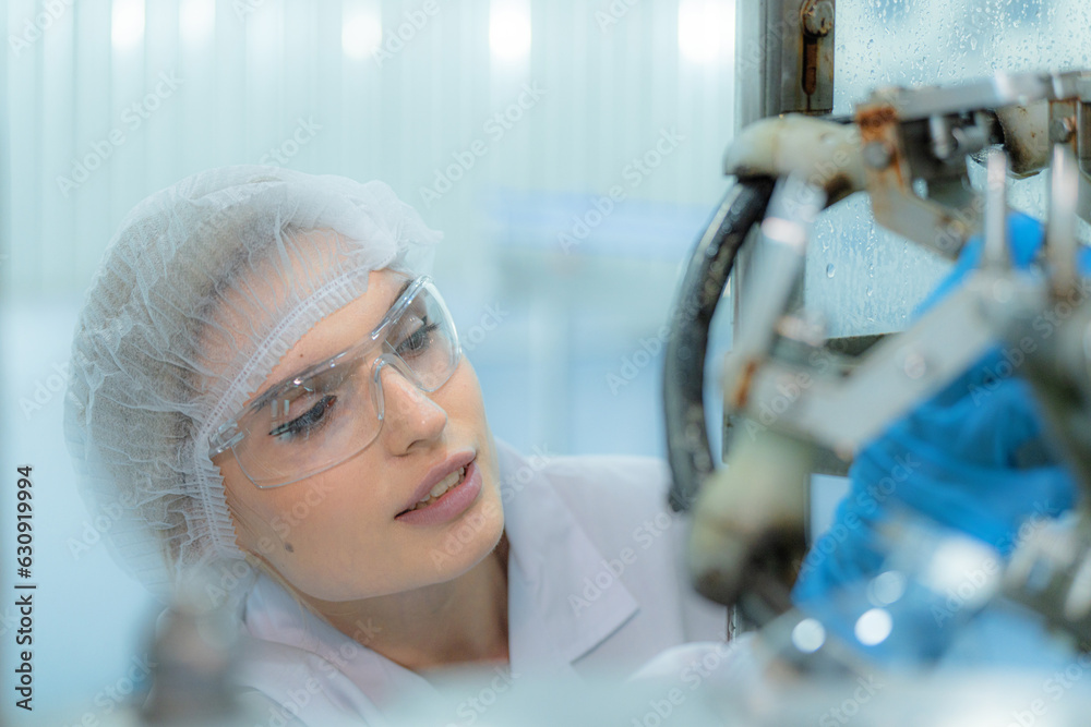 Factory woman engineer inspecting water dispenser on the machine. The ...