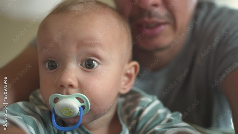 baby and father look at the camera video conference. baby and father ...