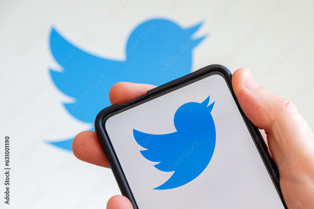 Hand holding a mobile phone with Twitter logo social media computer ...