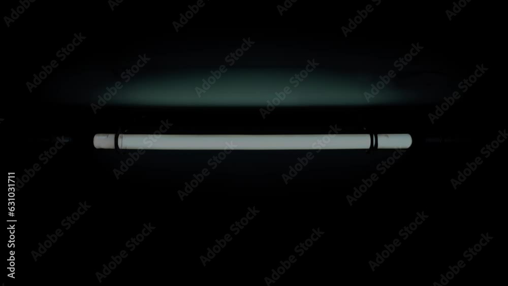 Scary neon light tube high on the ceiling of a dark basement, casting ...