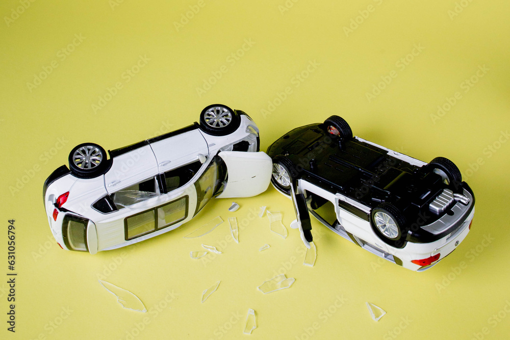 Two mini toy car crash on yellow background, incident, car traffic ...