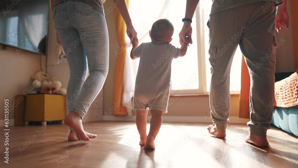 parents teach baby to walk. baby toddler taking first steps. happy ...