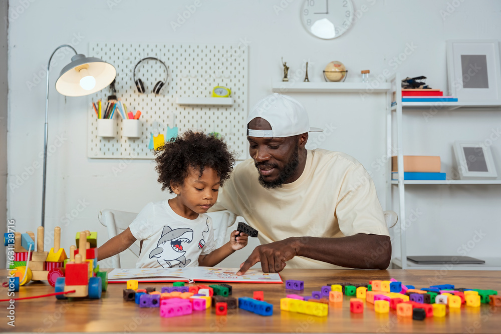 black father teaching his son how to read and watching his children ...