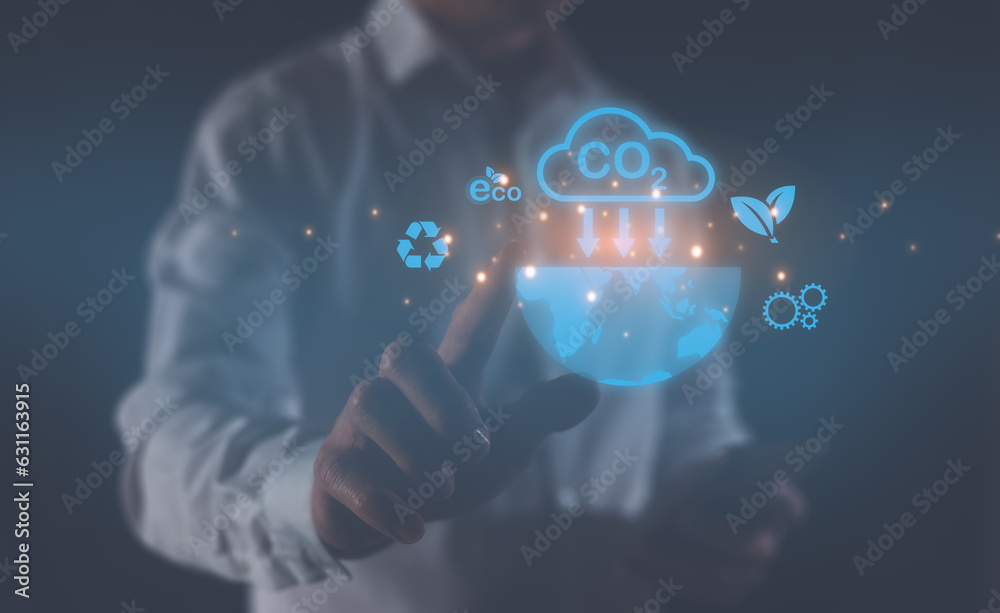 Hand touching CO2 reducing icon in concept of decrease carbon dioxide emission ,carbon footprint ...