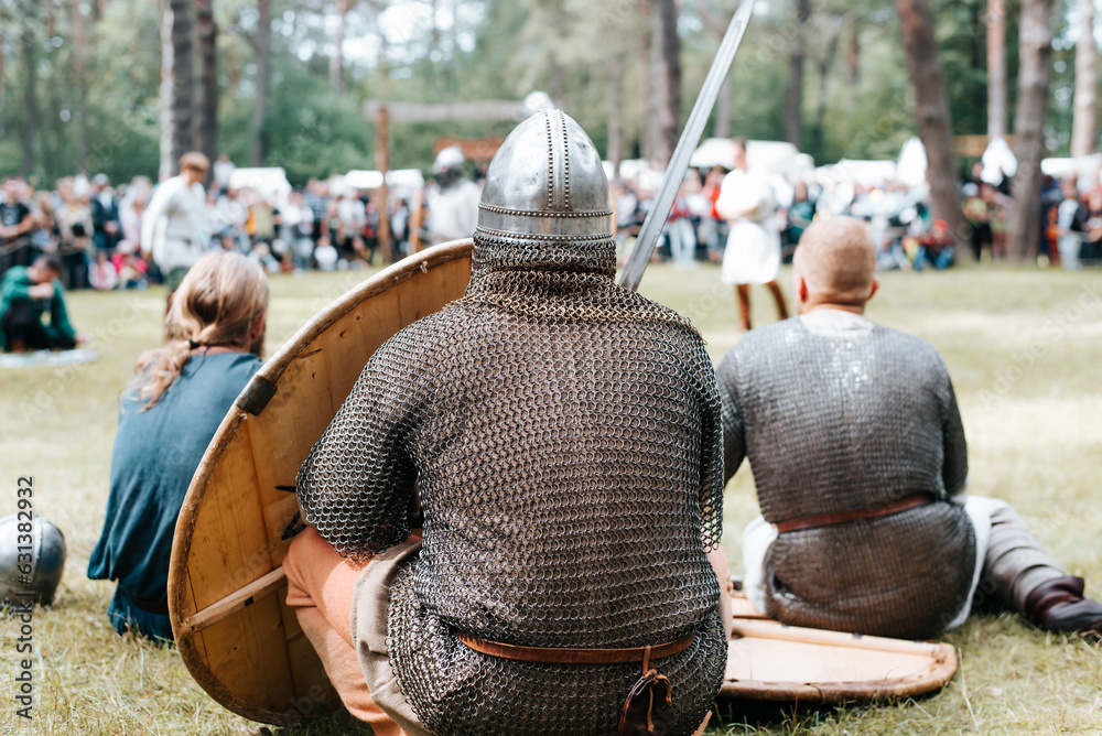 Resting warrior barbarian in armor, helmet and with a sword outdoors ...