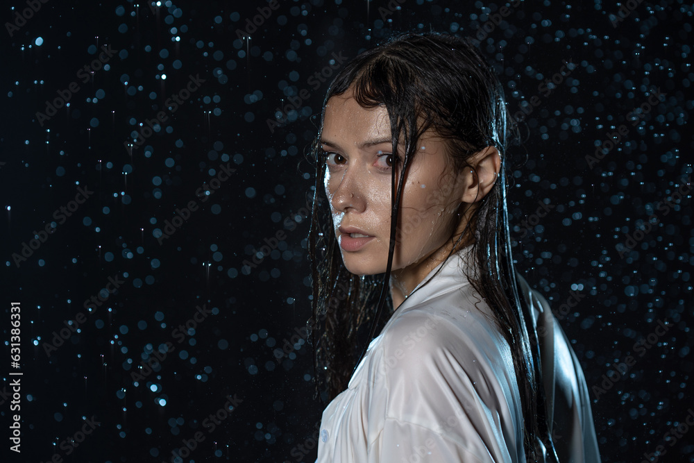 young woman in the rain, getting wet through, wet clothes and water ...