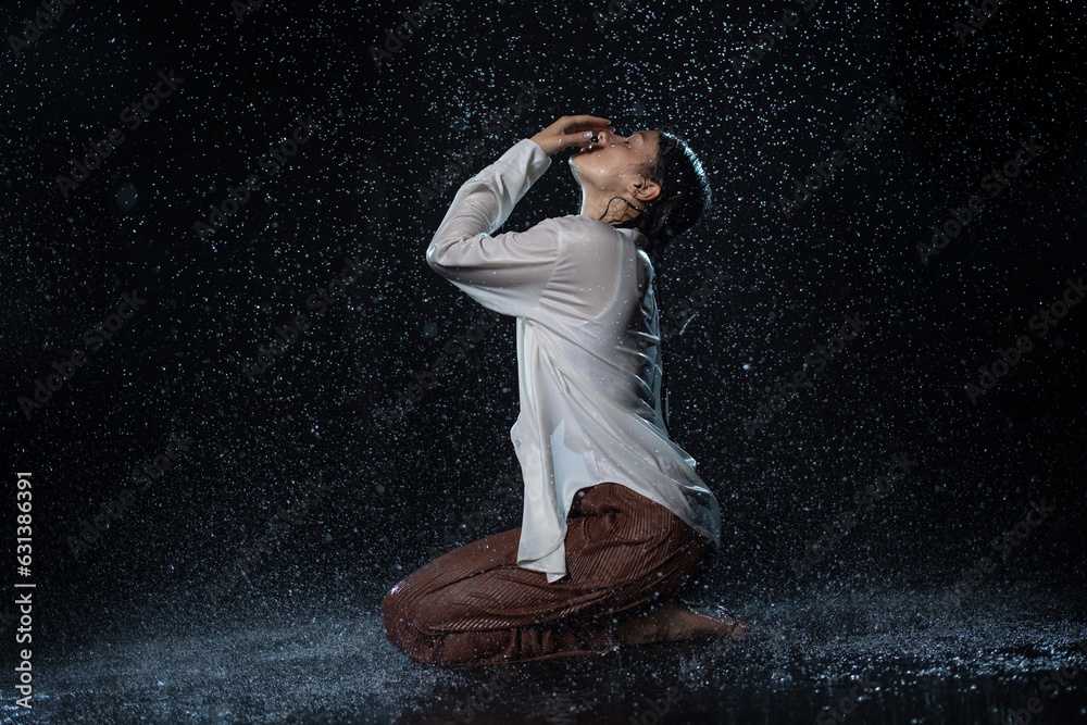 young woman in the rain, getting wet through, wet clothes and water ...