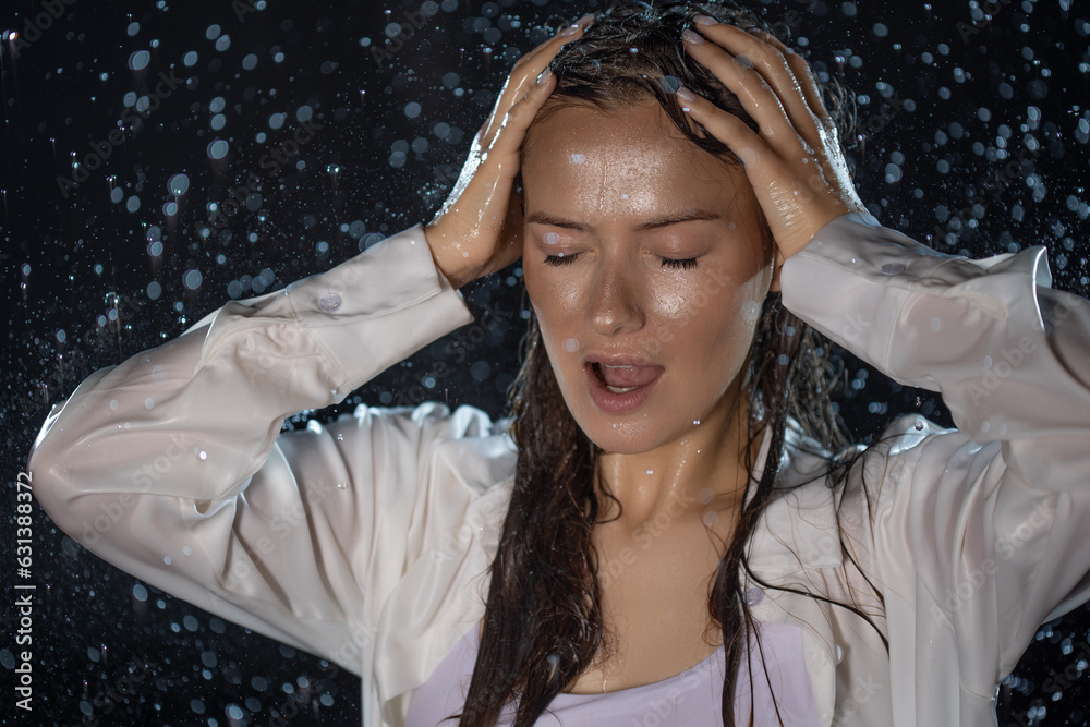 young woman in the rain, getting wet through, wet clothes and water ...