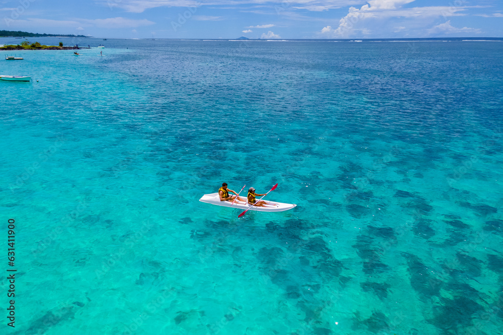 Mauritius vacation, couple man and woman in a kayak in a blue ocean in ...