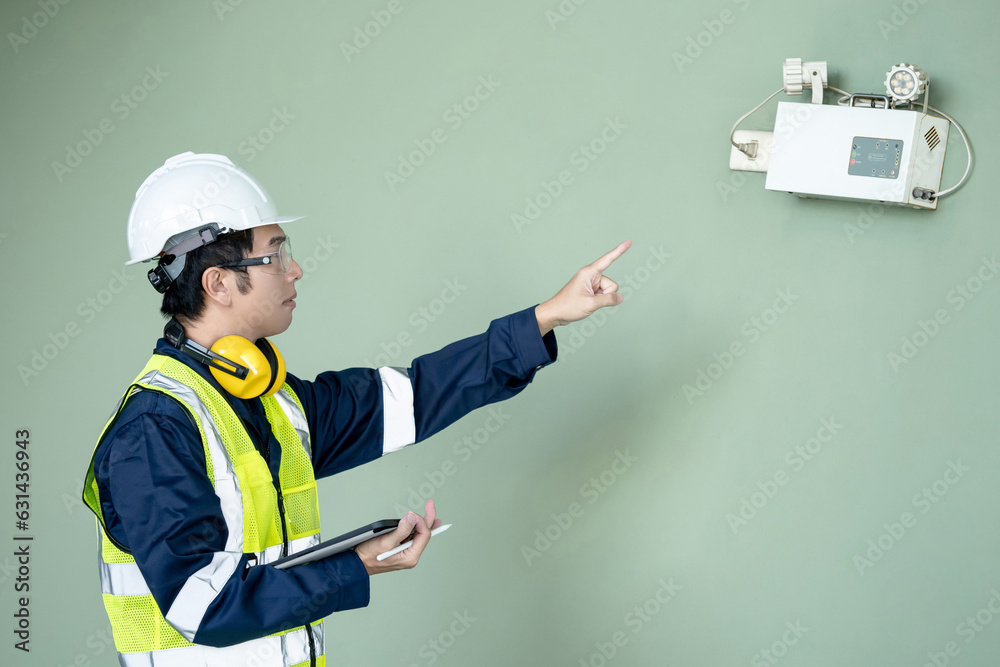 Building inspector man using digital tablet pointing at wall mounted ...