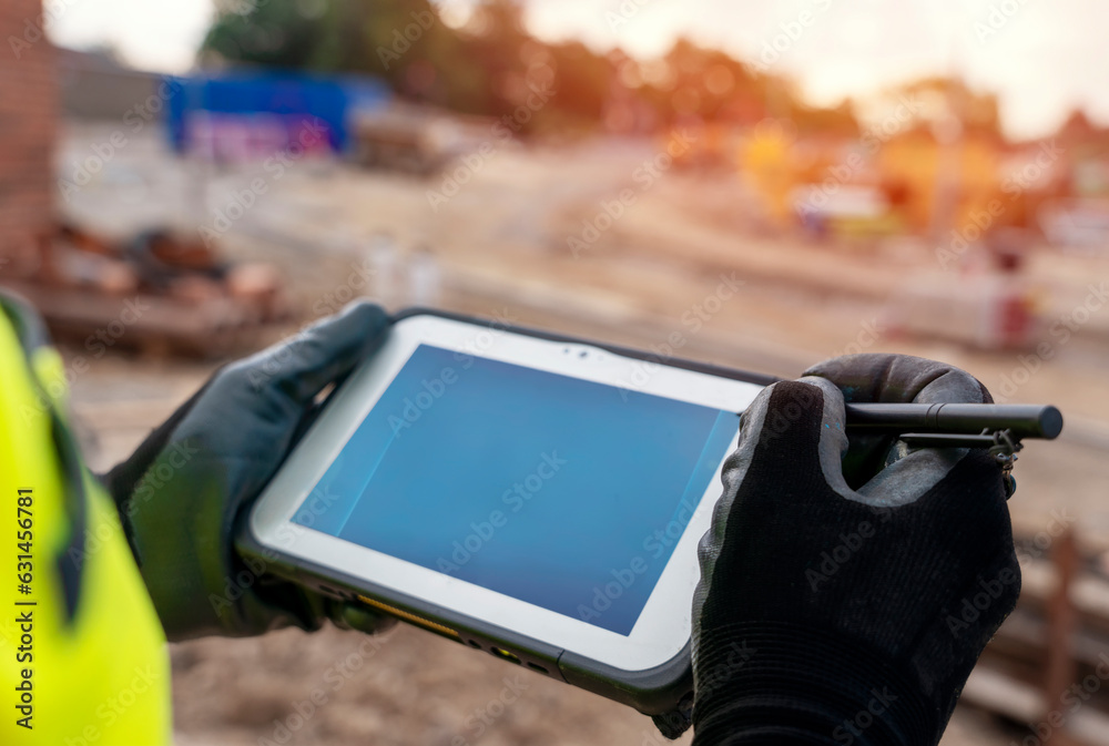 Site engineer surveyor using rugged tablet controller computer to ...