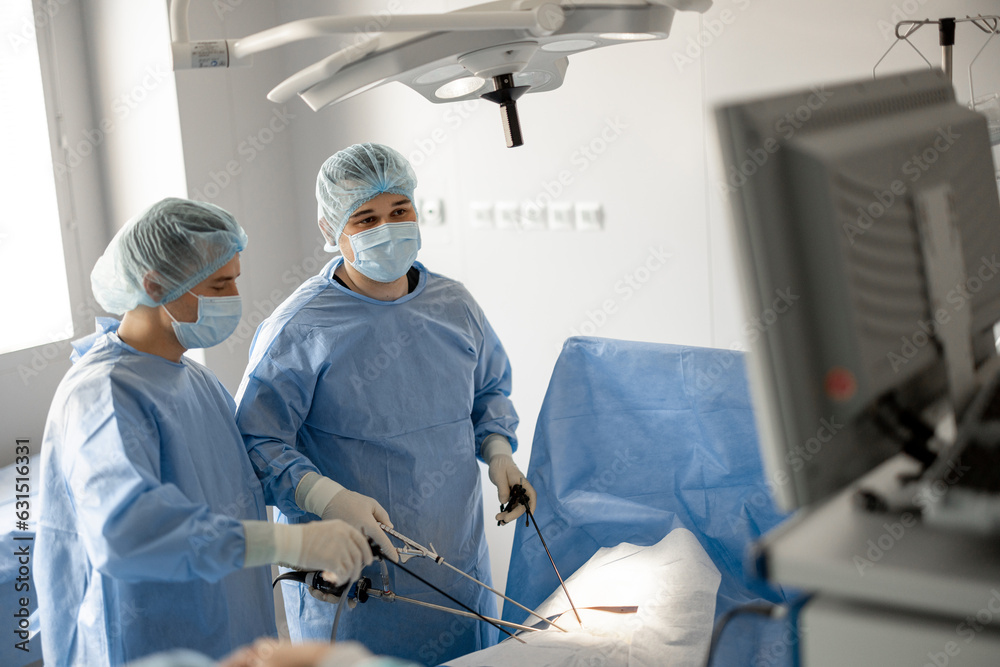 Foto de Two surgeons in uniform operate a patient with endscopes and ...