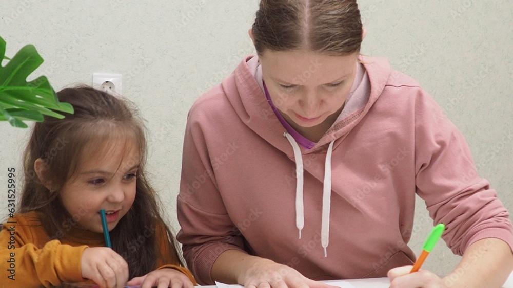 Little girl taking online art class with mother helping her at home ...