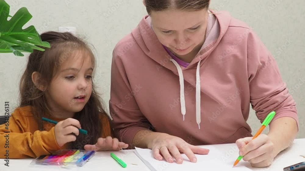 Vidéo Stock Little girl taking online art class with mother helping her ...