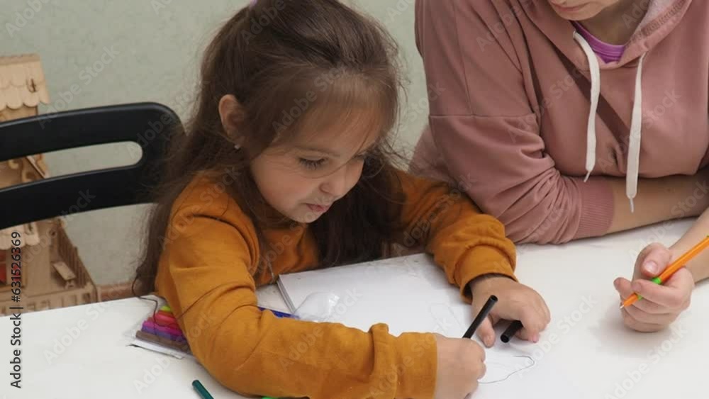 Little girl taking online art class with mother helping her at home ...