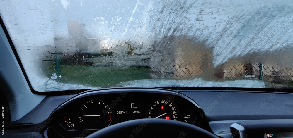 Dashboard view of a car windshield with rainwater streaming down the ...