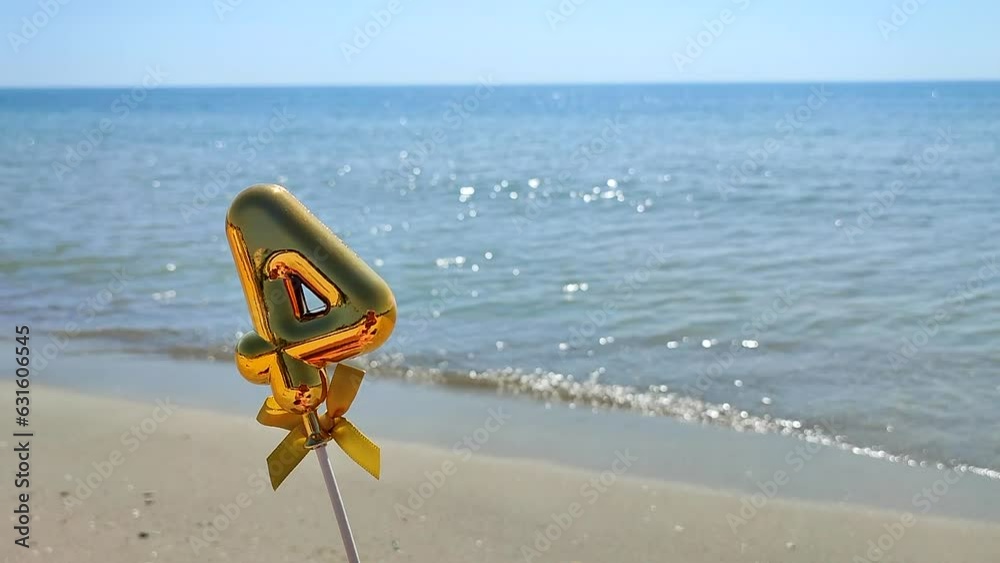 Person holding stick with a shiny golden number 4 four in his hand ... Person holding stick with a shiny golden number 4 four in his hand ...