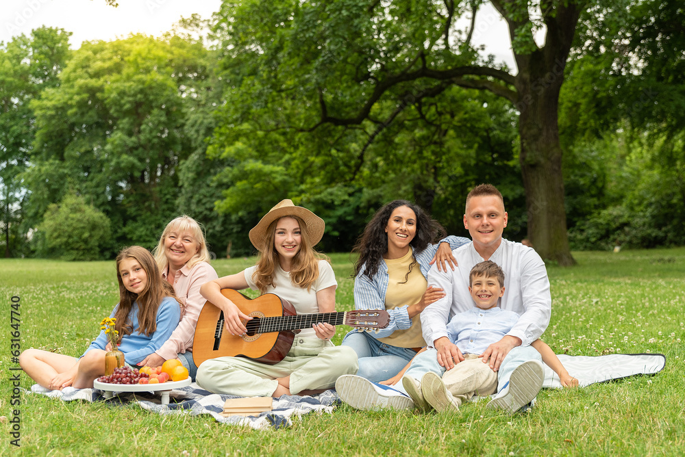 Happy multi generational mixed race family sitting enjoy picnic ...