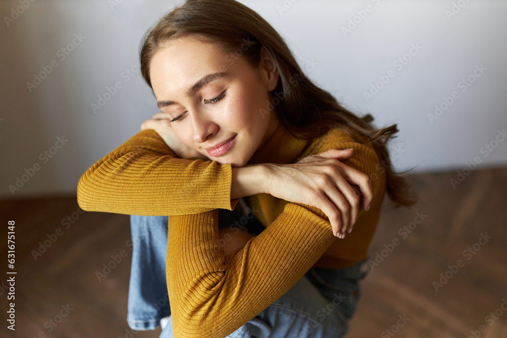 Closeup portrait of cute romantic girl sitting with head on knees ...
