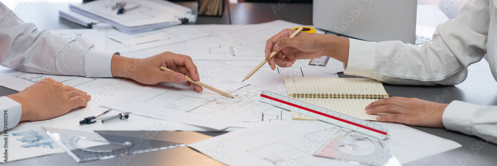 Engineer partner drawing and working on blueprint design together on ...