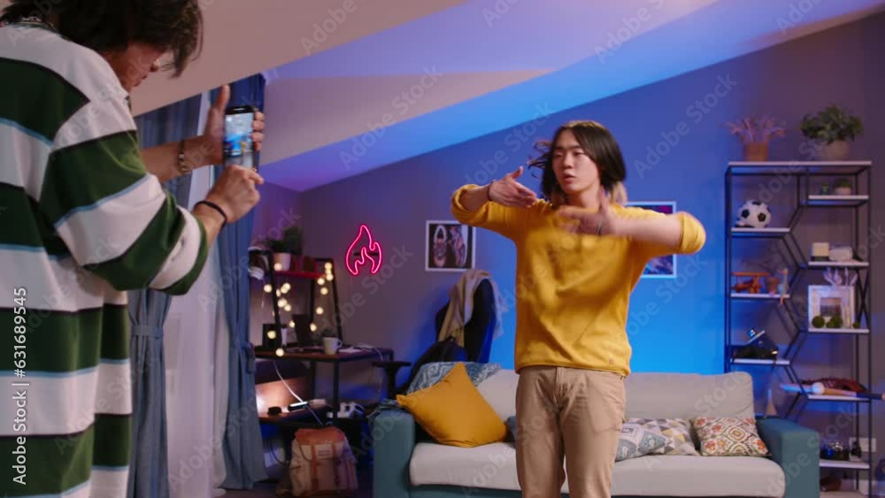 Long-haired Asian guy dancing for video. Two Asian friends teenage guys ...