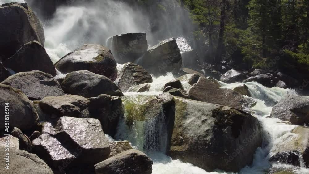 Close-up view of a river crashing on massive rocks in a wild nature ...