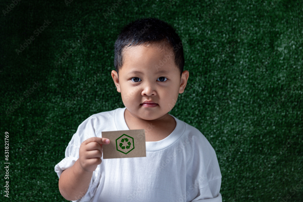 Cute little Asian boy holding a brown recycled paper card with ...