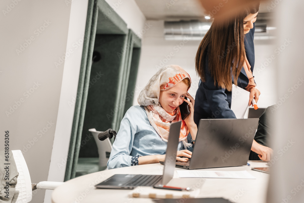 Muslim ginger female employee wearing a hijab having a phone call and ...