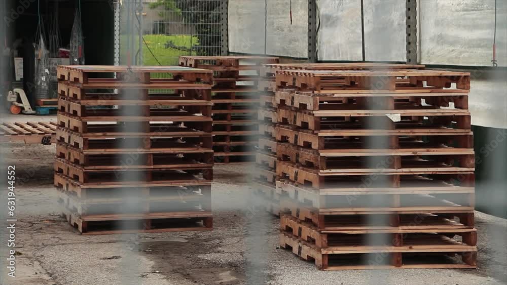 tight shot, piles of wood palettes skids, pavement, outdoor canopy tent ...