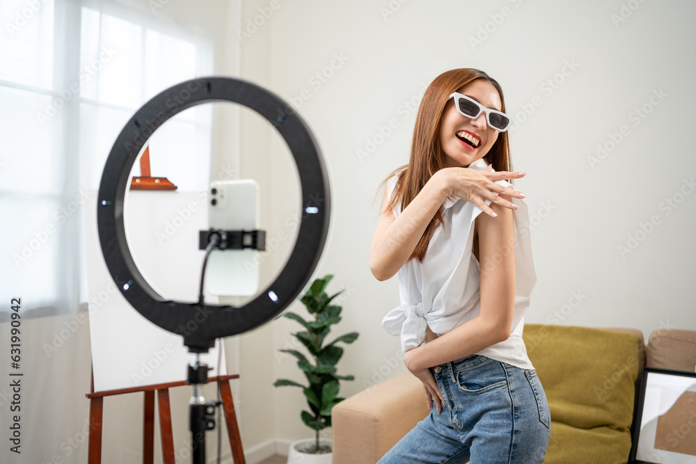 Young trendy influencer asian woman dancing on mobile phone at home in ...