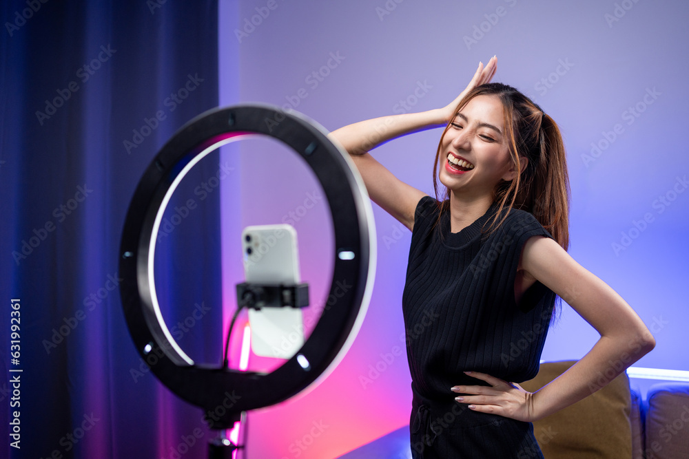 Young trendy influencer asian woman dancing on mobile phone at home in ...