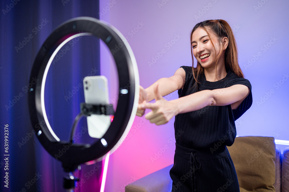 Young trendy influencer asian woman dancing on mobile phone at home in ...