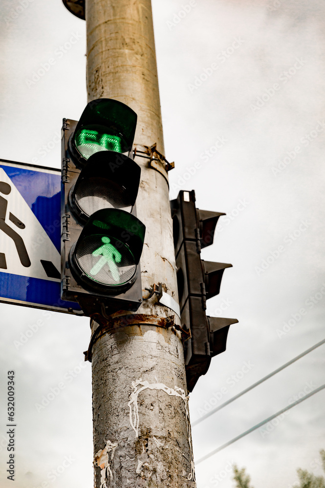 The traffic light shows a green light. Two traffic lights and a sign on ...