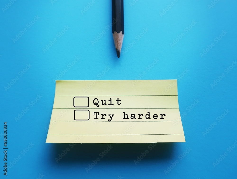 Pencil on blue background with tick box note written QUIT and TRY ...