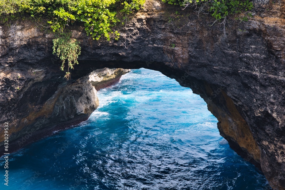 Big stone arch across the deep blue sea. Natural bridge over the ocean ...