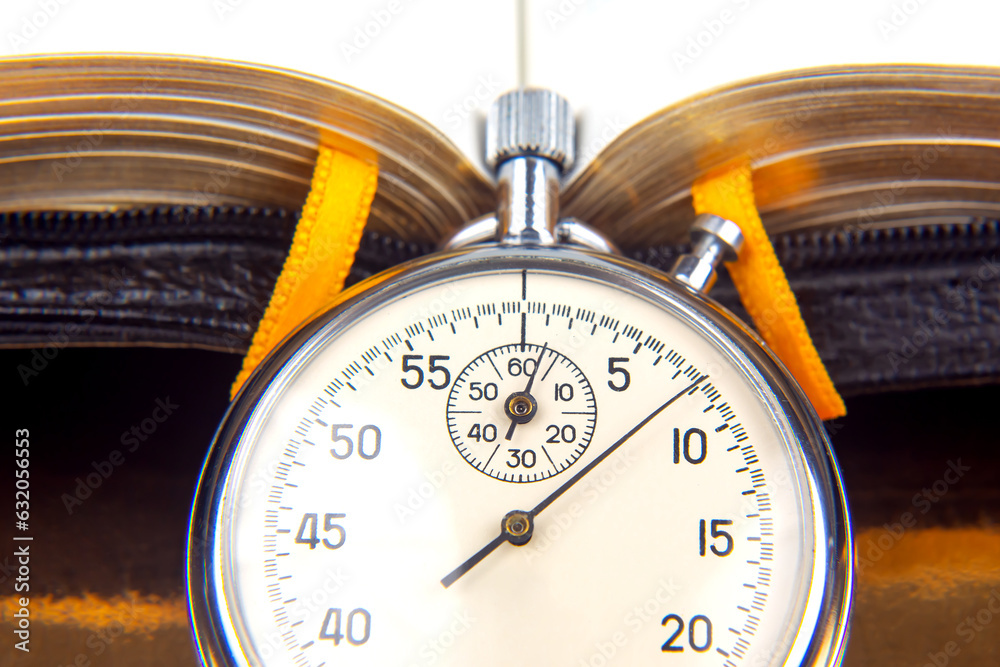 mechanical analog stopwatch on the background of an open book. Time ...