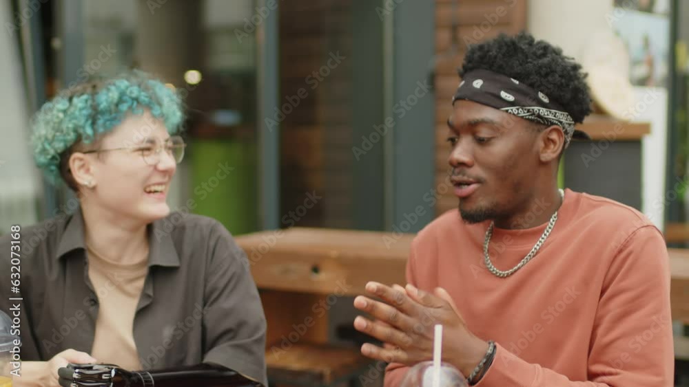 Diverse gen Z couple having fun in street cafe, young African American ...