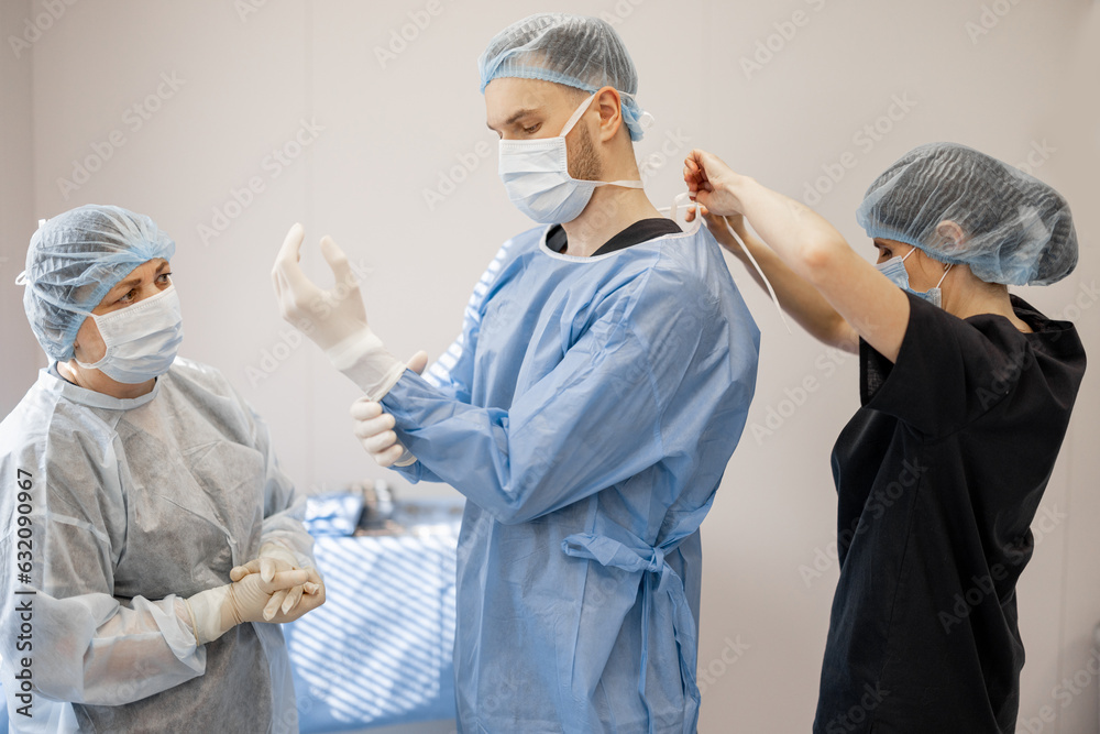 Poster Nurse with surgeon preparing for an operation, wearing sterile ...
